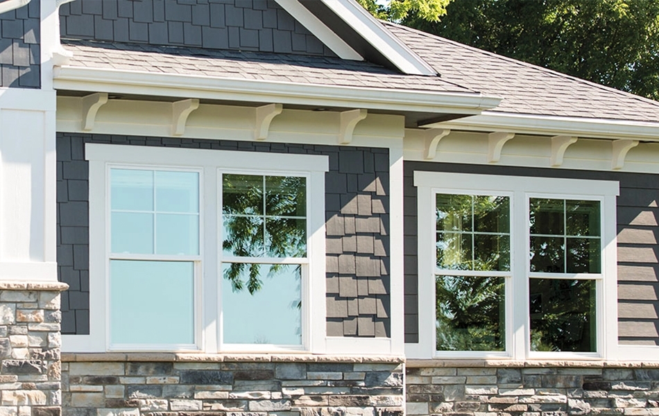 a cape cod home with blue siding and brick trim